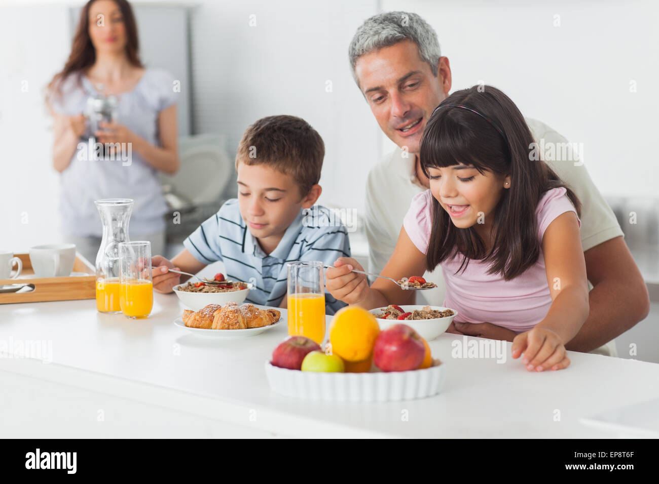 Cute family eating breakfast in kitchen together Stock Photo - Alamy