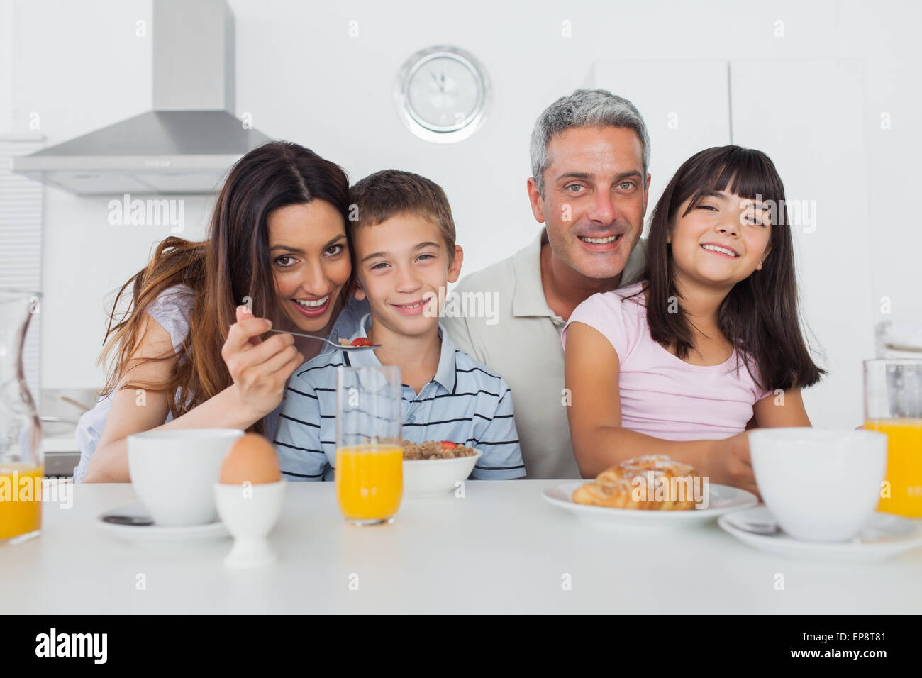 Beautiful family eating breakfast in kitchen together Stock Photo - Alamy