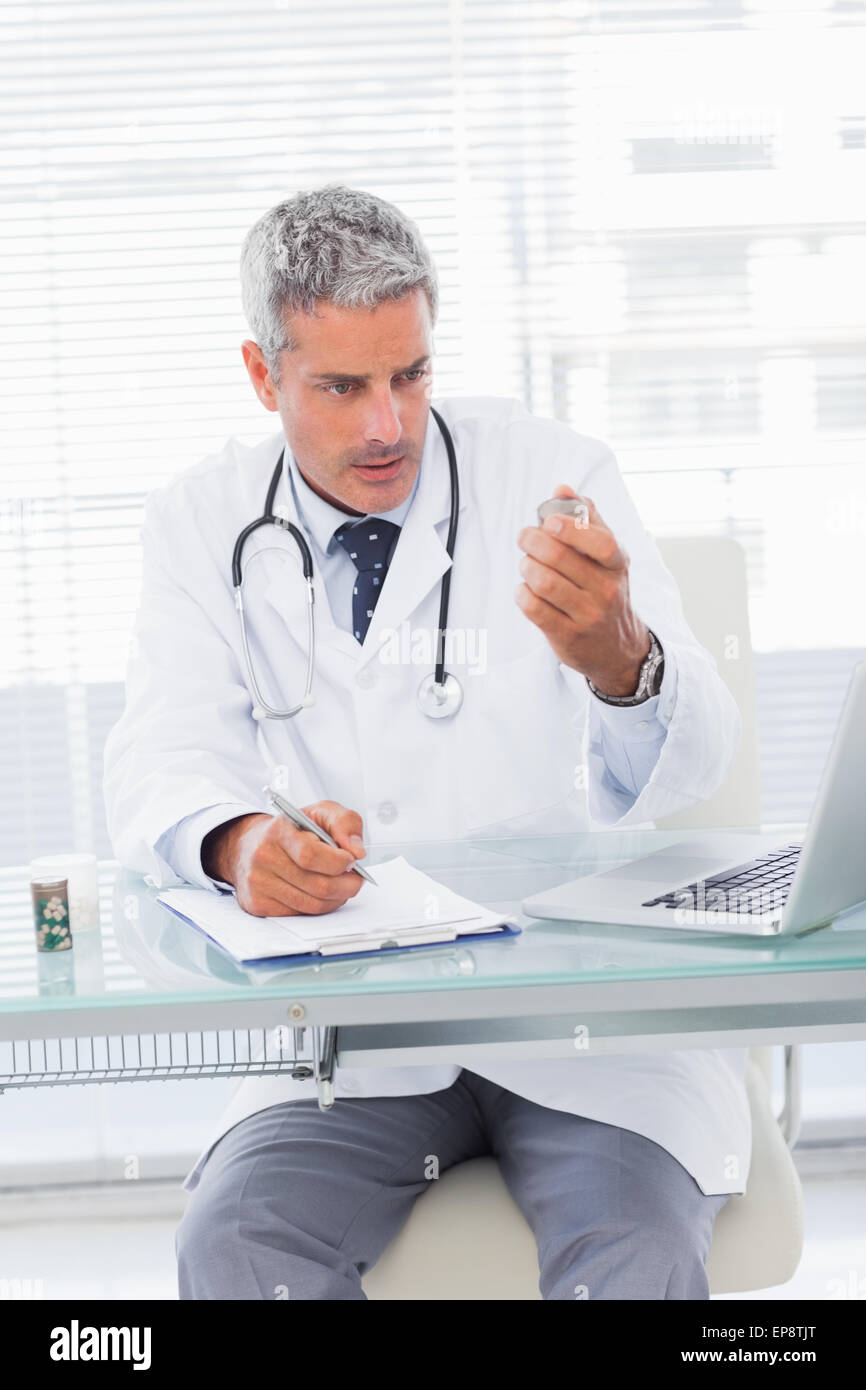 Serious doctor looking a medication for a prescription Stock Photo - Alamy