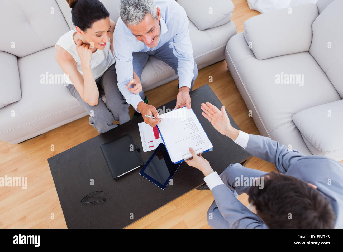 Salesman showing contract to couple who are about to sign Stock Photo ...