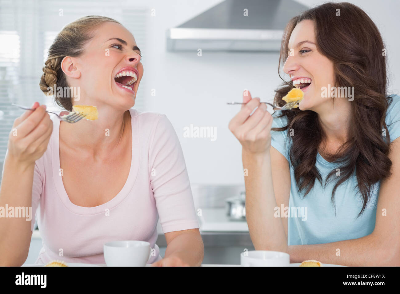 Laughing friends eating cake and having coffee Stock Photo - Alamy