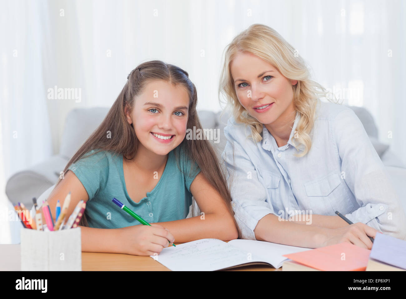 Woman helping her daughter doing her homework Stock Photo - Alamy