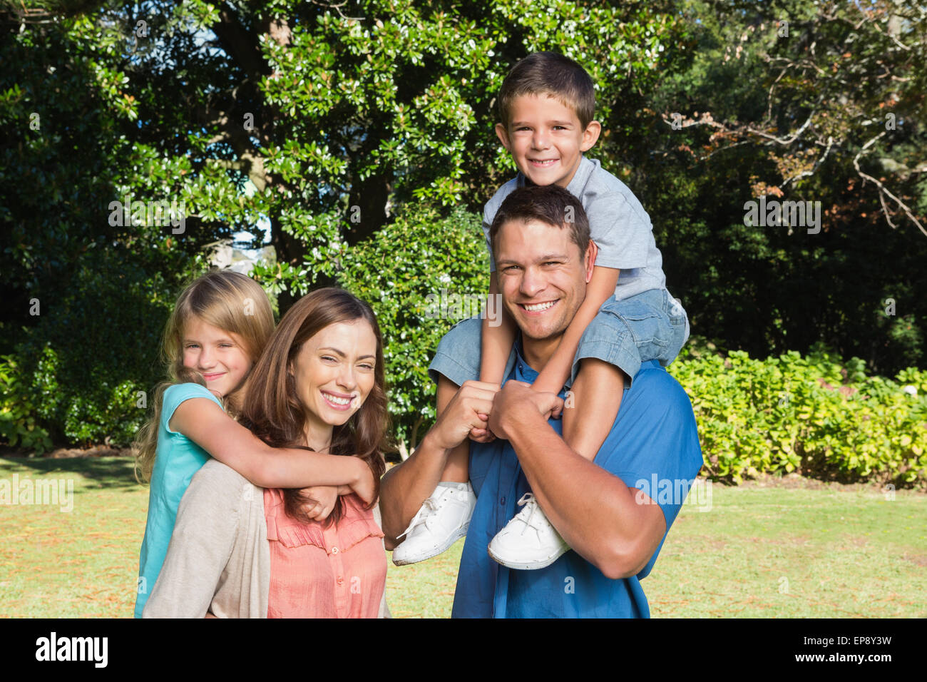 Happy family with children on their shoulders Stock Photo - Alamy