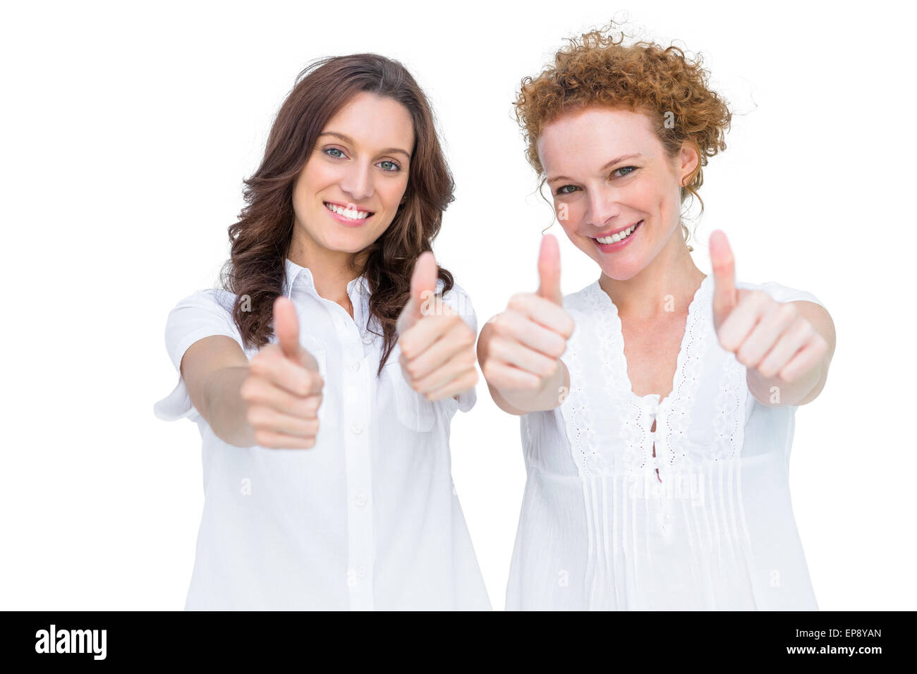 Two beautiful casual models posing with thumbs up Stock Photo - Alamy
