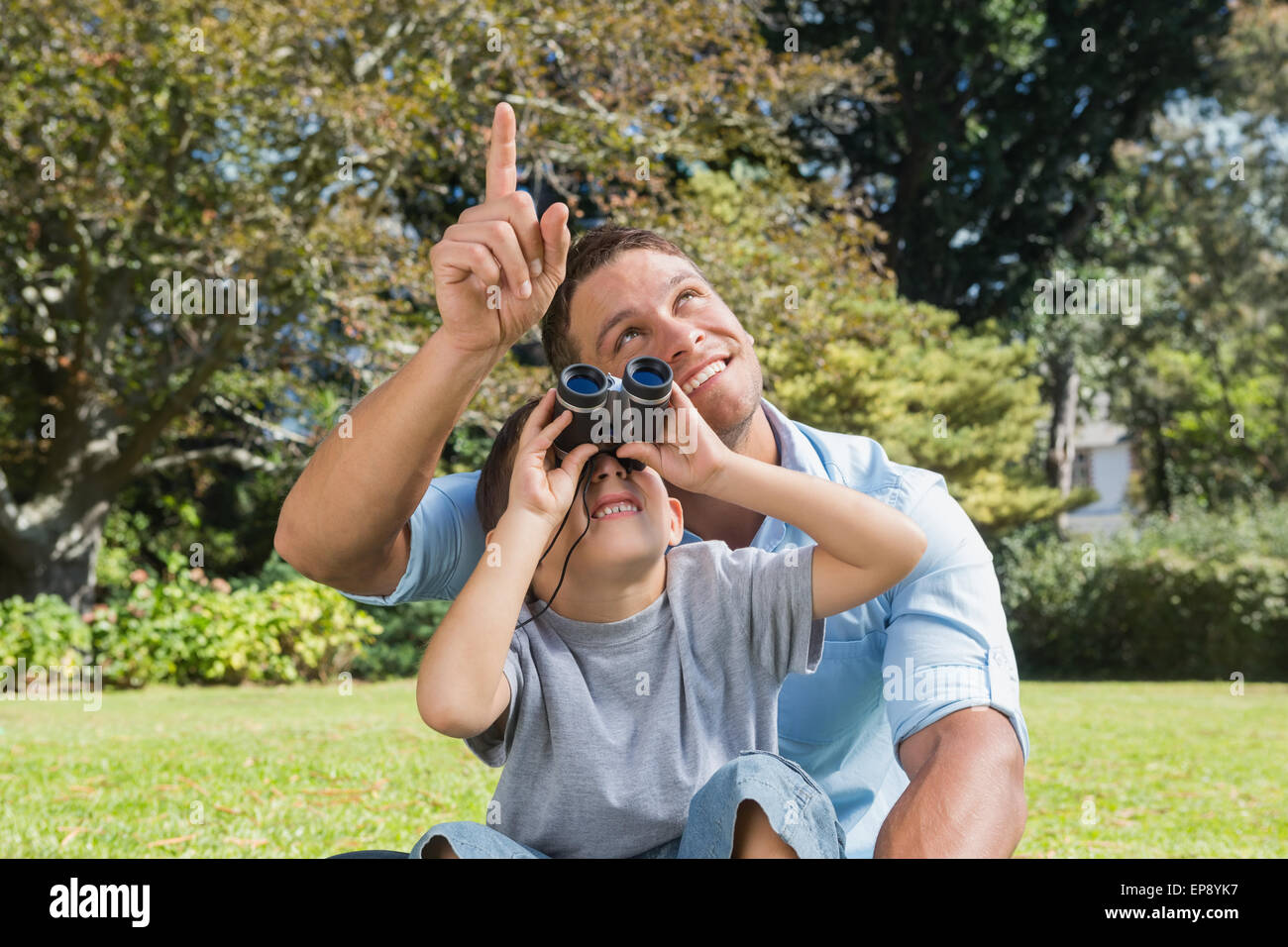 Dad and son looking at the sky with binoculars Stock Photo - Alamy