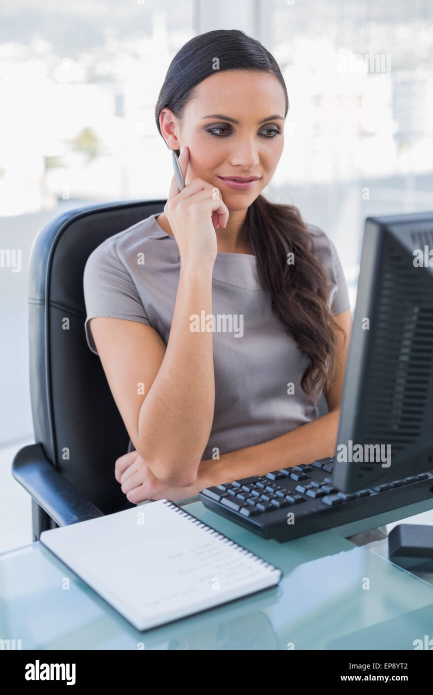Thoughtful gorgeous businesswoman looking at her computer screen Stock ...