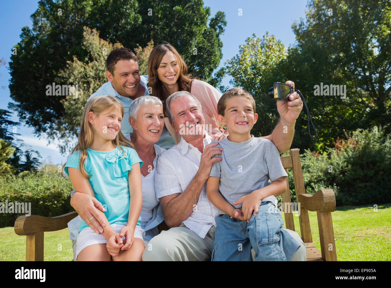 Family sitting on a bench taking photo of themselves Stock Photo - Alamy