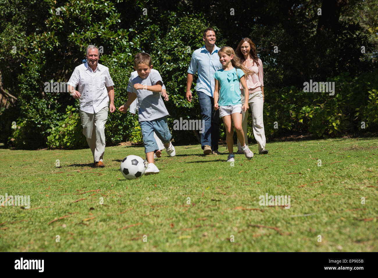 Happy multi generation family playing football Stock Photo - Alamy