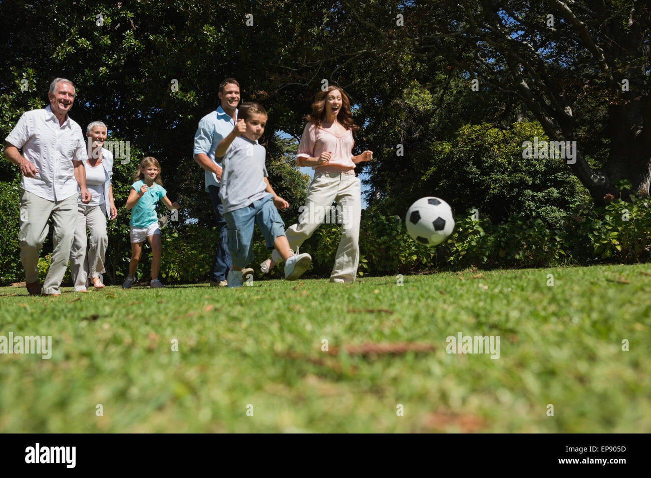 Cheerful multi generation family playing football Stock Photo - Alamy