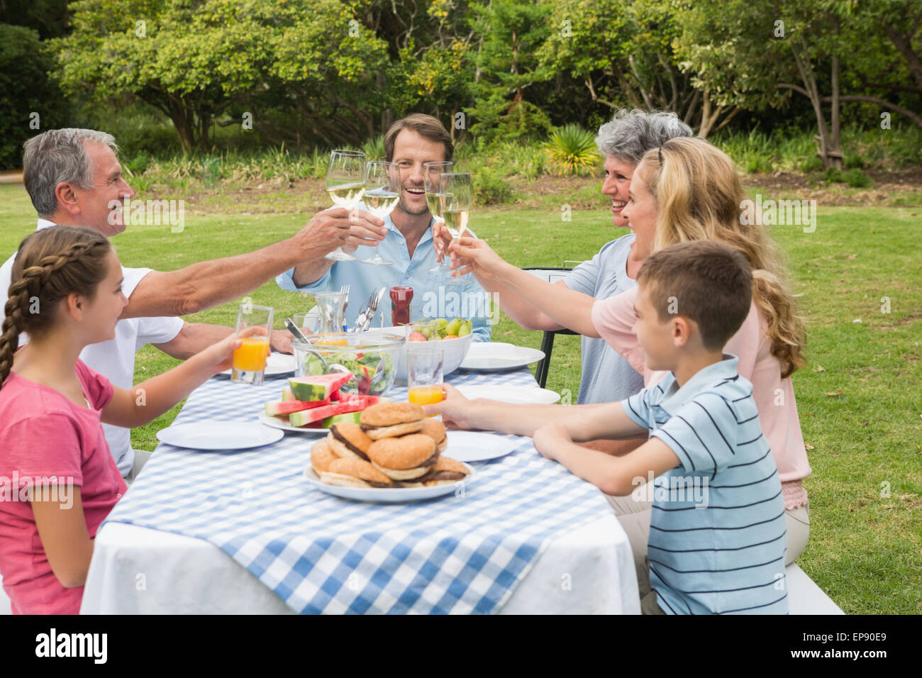 Multi generation family toasting each other at dinner outside Stock ...