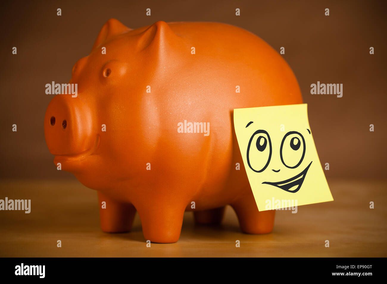 Post-it note with smiley face sticked on piggy bank Stock Photo - Alamy