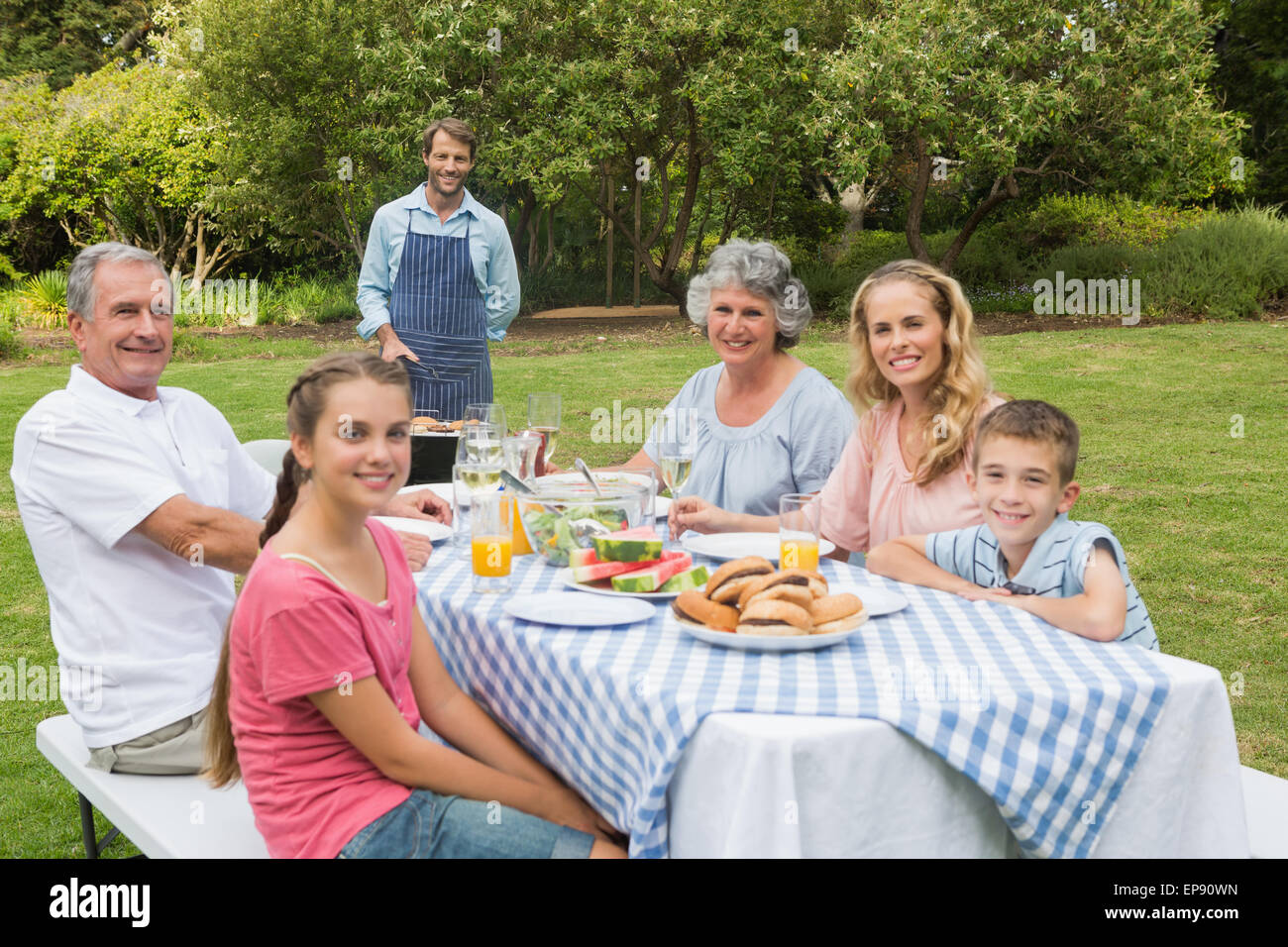 Happy extended family having a barbecue being cooked by father Stock ...