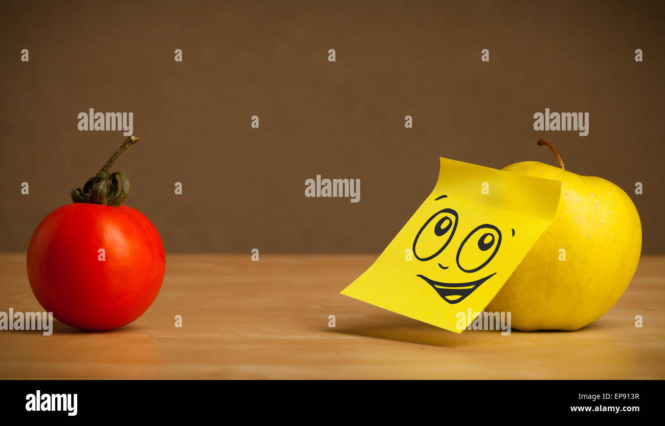Apple with post-it note looking at tomato Stock Photo - Alamy