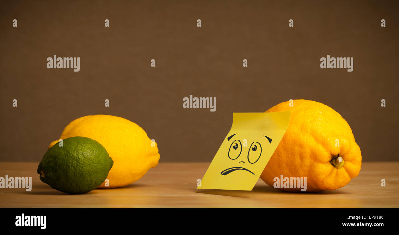 Lemon with sticky post-it note looking sadly at citrus fruits Stock ...