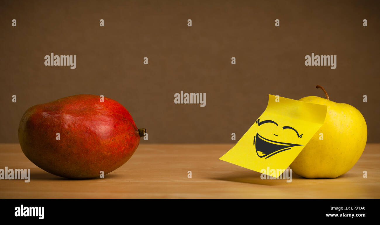 Apple with post-it note laughing on mango Stock Photo - Alamy