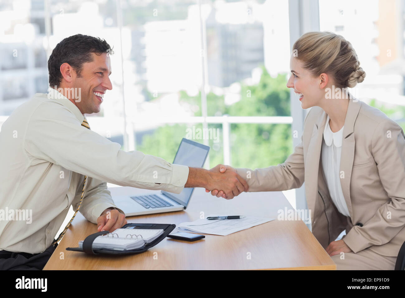 Blonde woman shaking hands while having an interview Stock Photo - Alamy