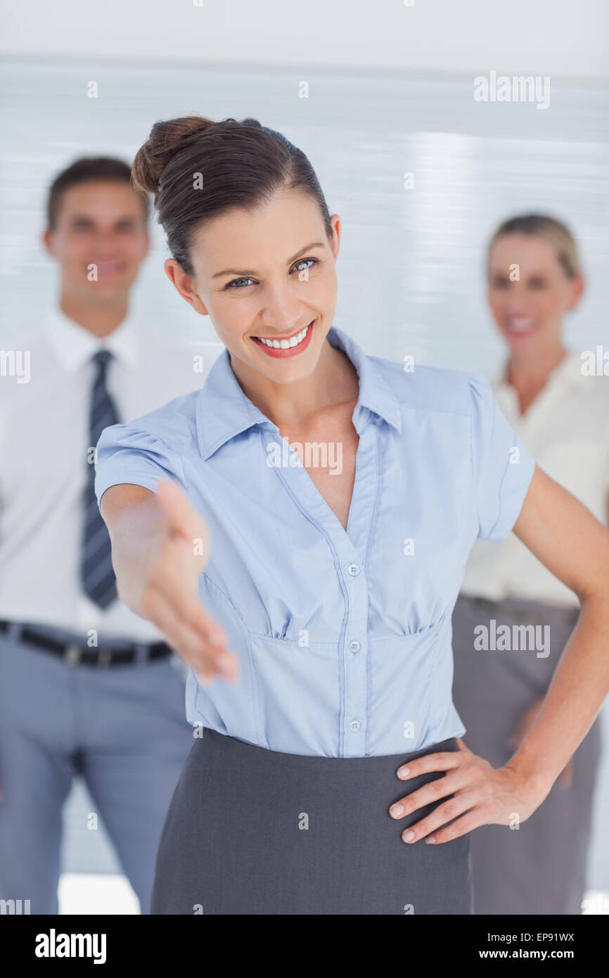 Smiling businesswoman holding out her hand to camera Stock Photo - Alamy