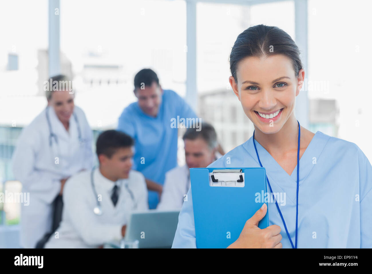 Cheerful young surgeon posing with colleagues in background Stock Photo ...