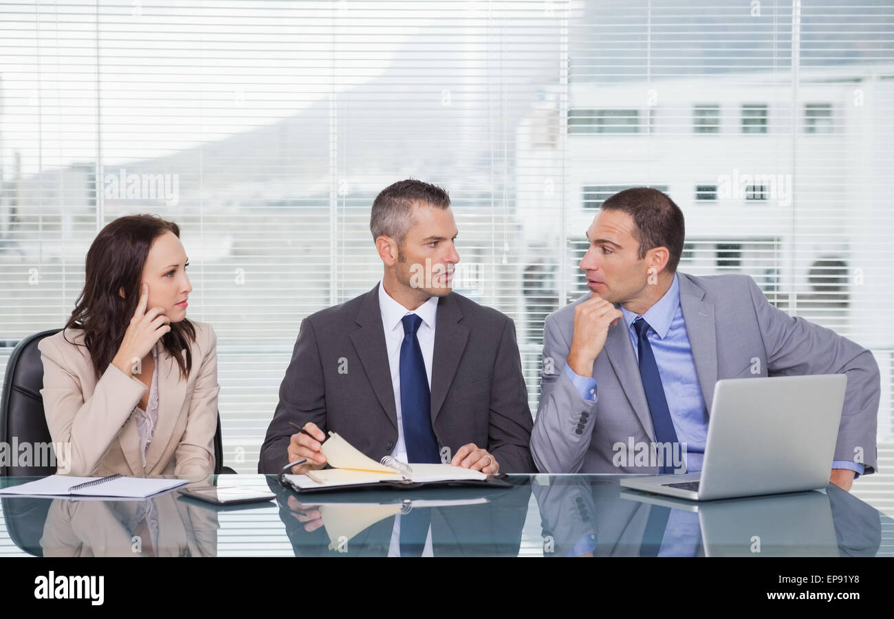 Serious business people talking together while waiting for interview ...