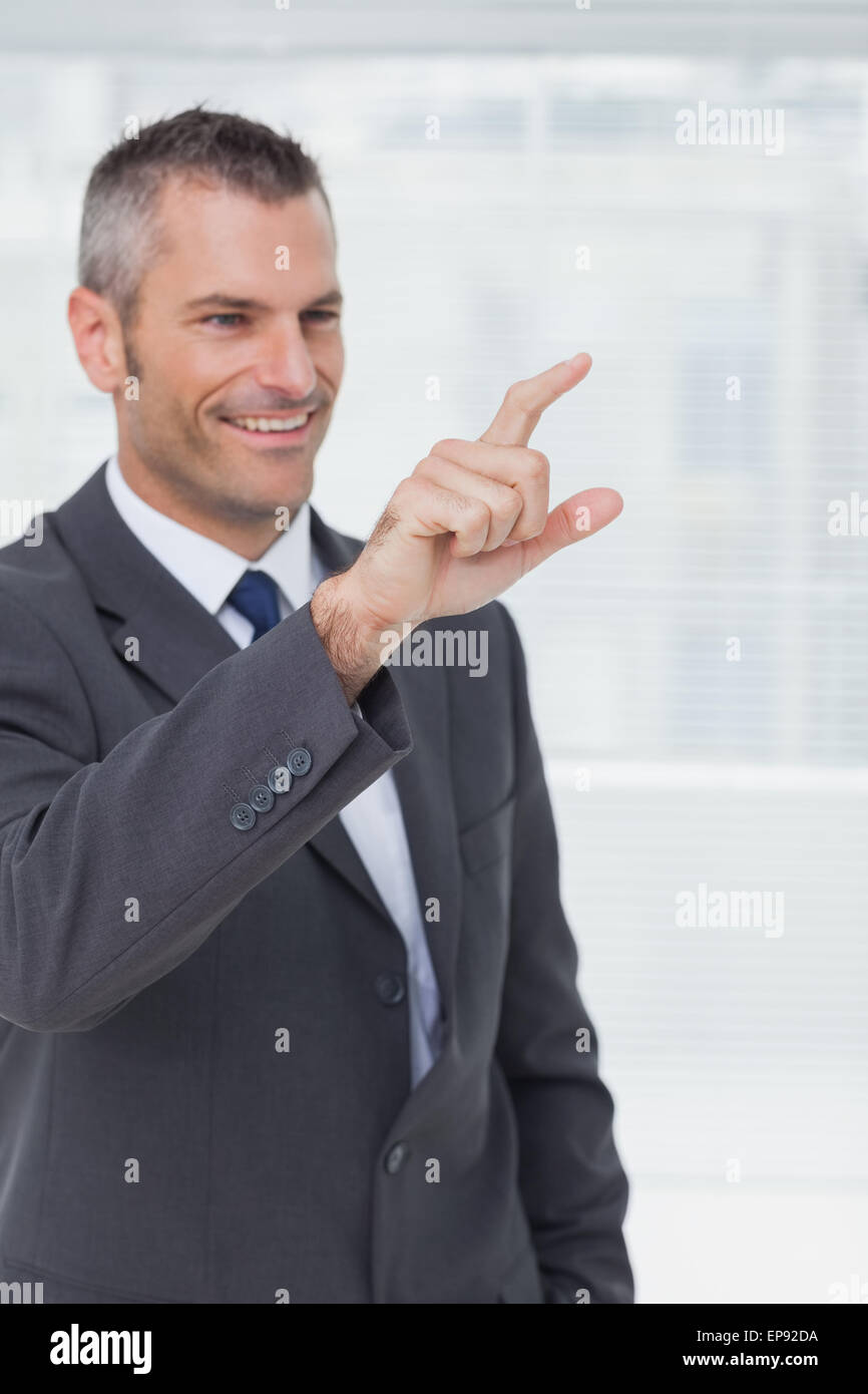 Cheerful businessman pointing and looking straight ahead Stock Photo ...