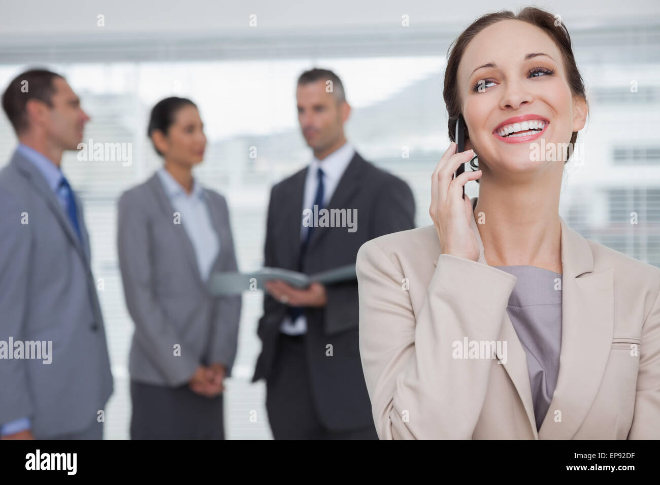 Cheerful businesswoman calling while colleagues talking together Stock ...
