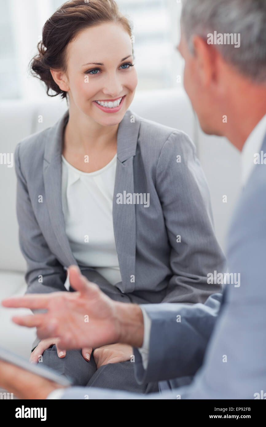 Smiling businesswoman listening to her workmate talking Stock Photo - Alamy