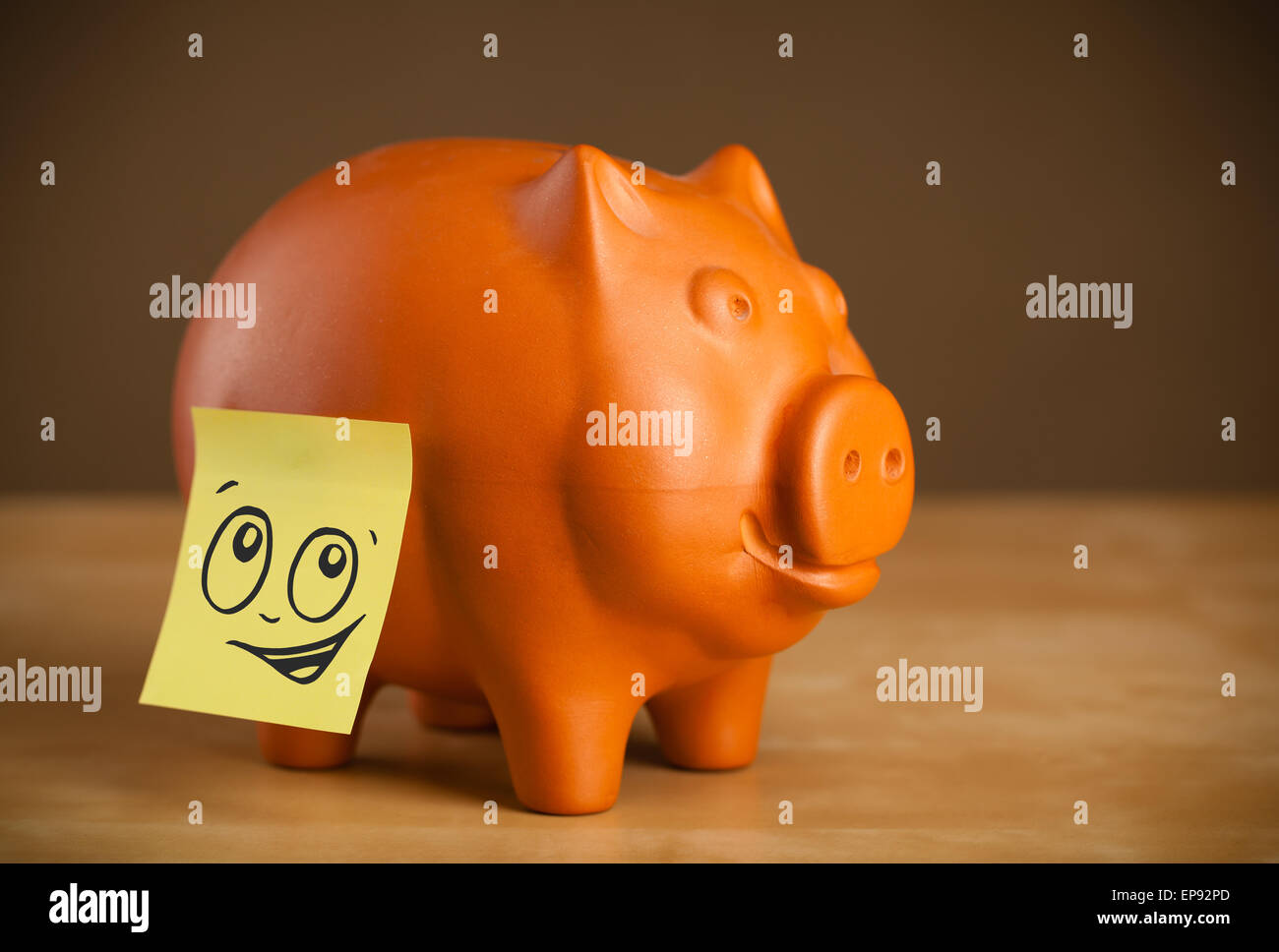 Post-it note with smiley face sticked on piggy bank Stock Photo - Alamy