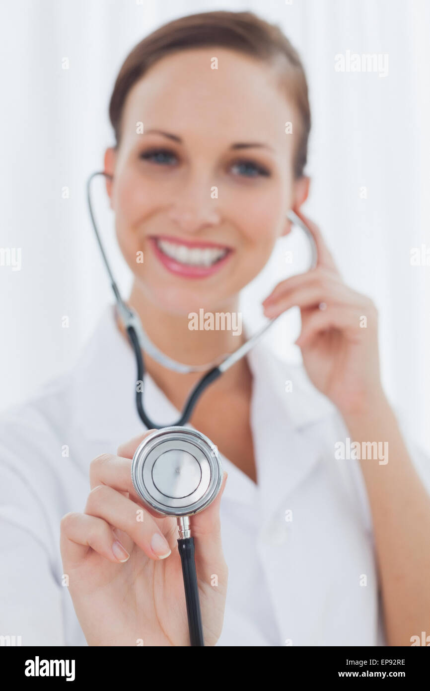Smiling pretty nurse posing holding her stethoscope Stock Photo - Alamy