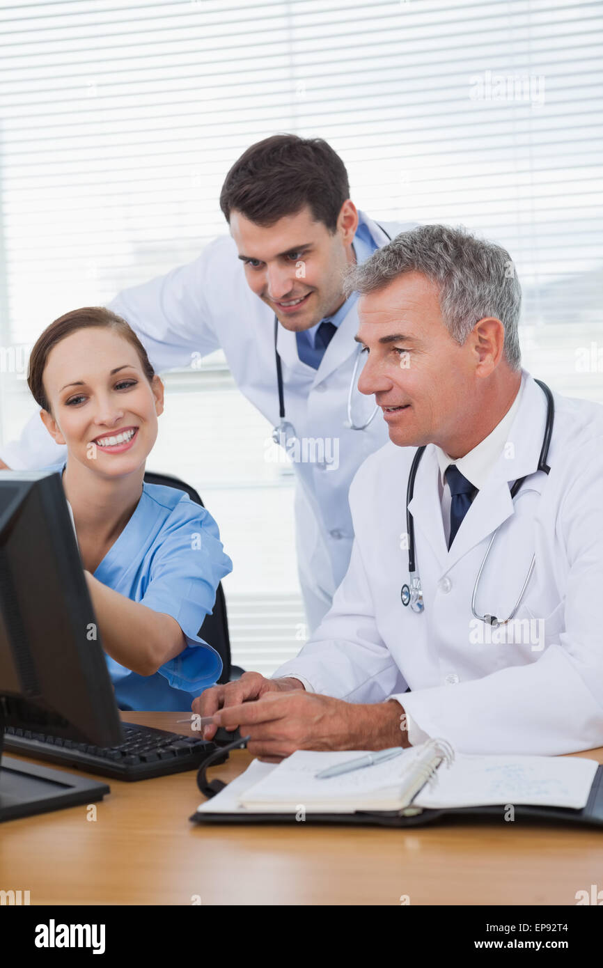 Smiling surgeon working with doctors on computer Stock Photo - Alamy
