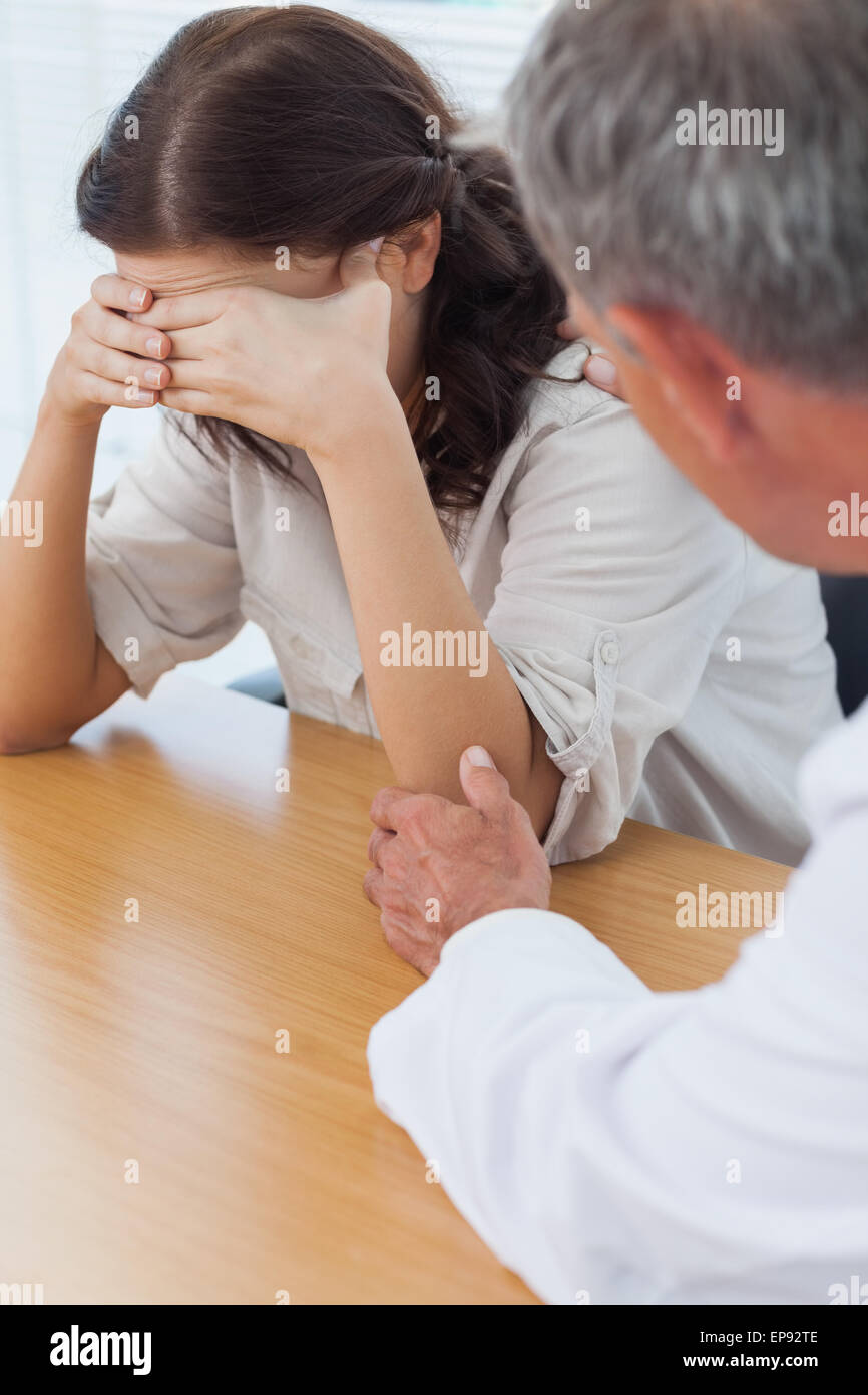Upset patient crying while doctor comforting her Stock Photo - Alamy