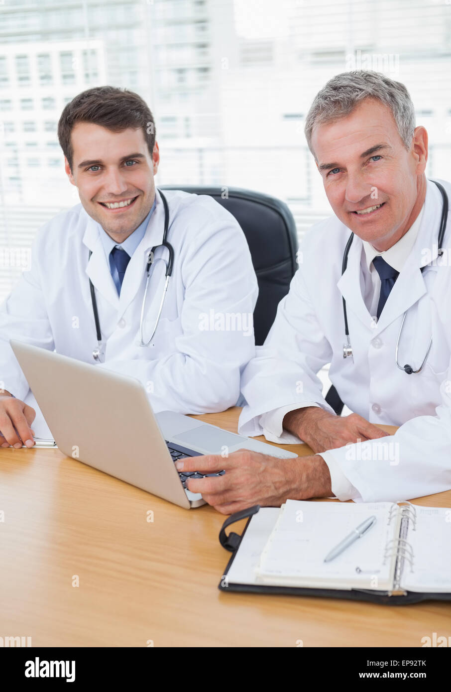 Doctors posing while working together on laptop Stock Photo - Alamy