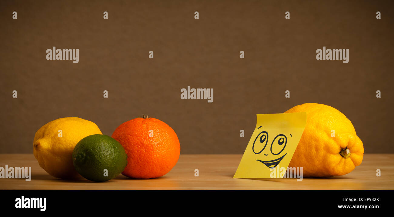 Lemon with post-it note looking at citrus fruits Stock Photo - Alamy