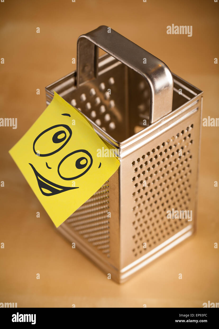 Post-it note with smiley face sticked on grater Stock Photo - Alamy