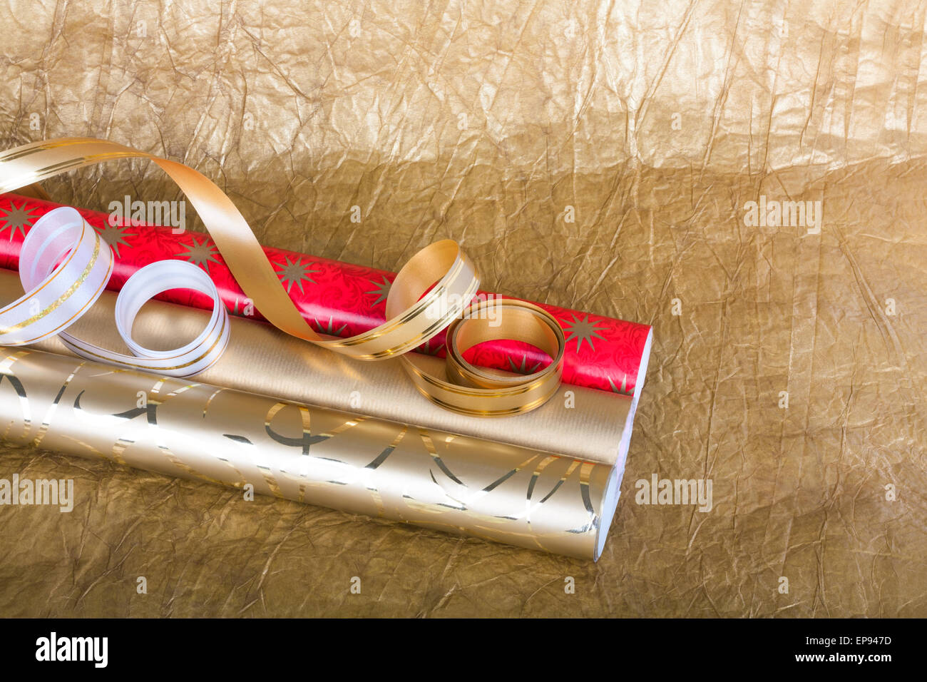 Rolls of multicolored wrapping paper with streamer for gifts on gold ...