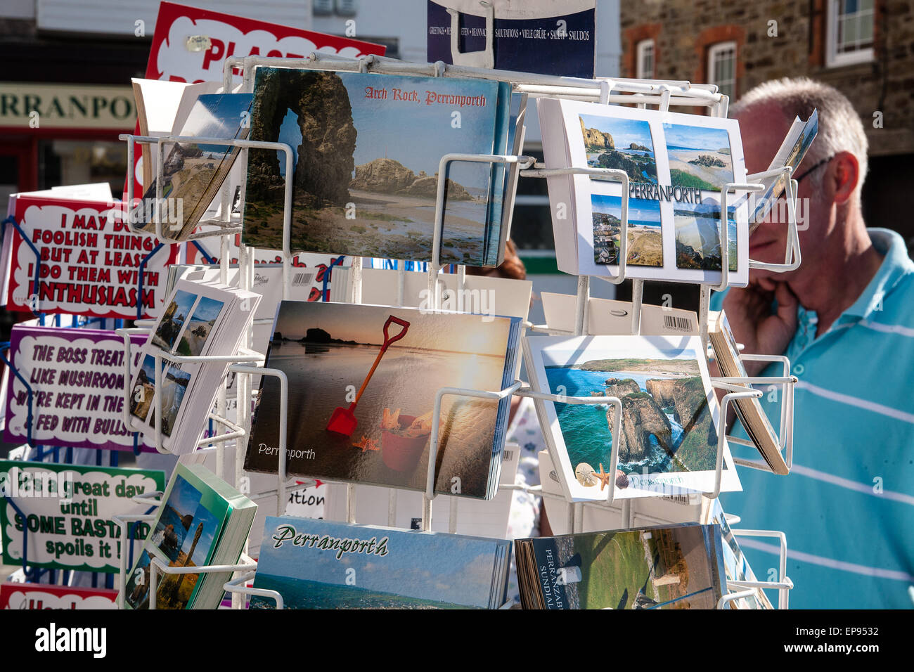 Looking at postcards at tourist shop on High Street in Perranporth, a ...