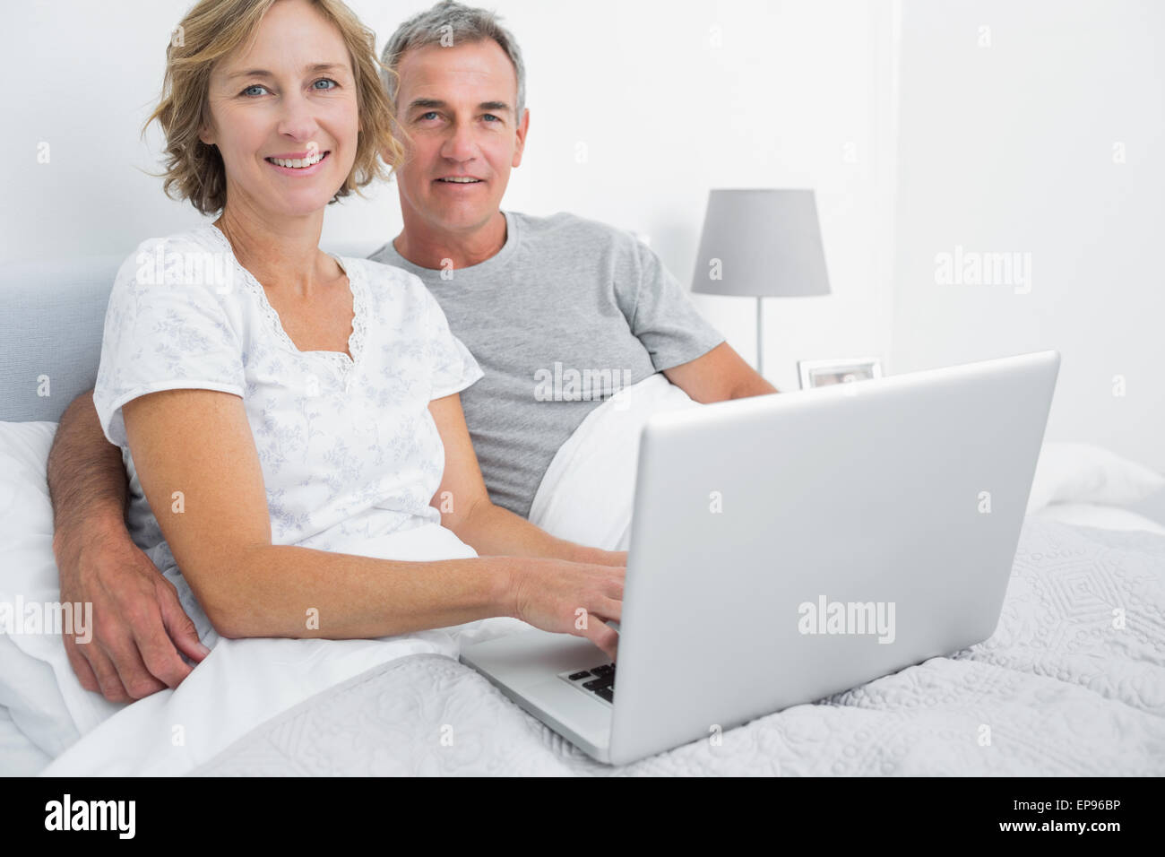Relaxed couple using their laptop together in bed Stock Photo - Alamy