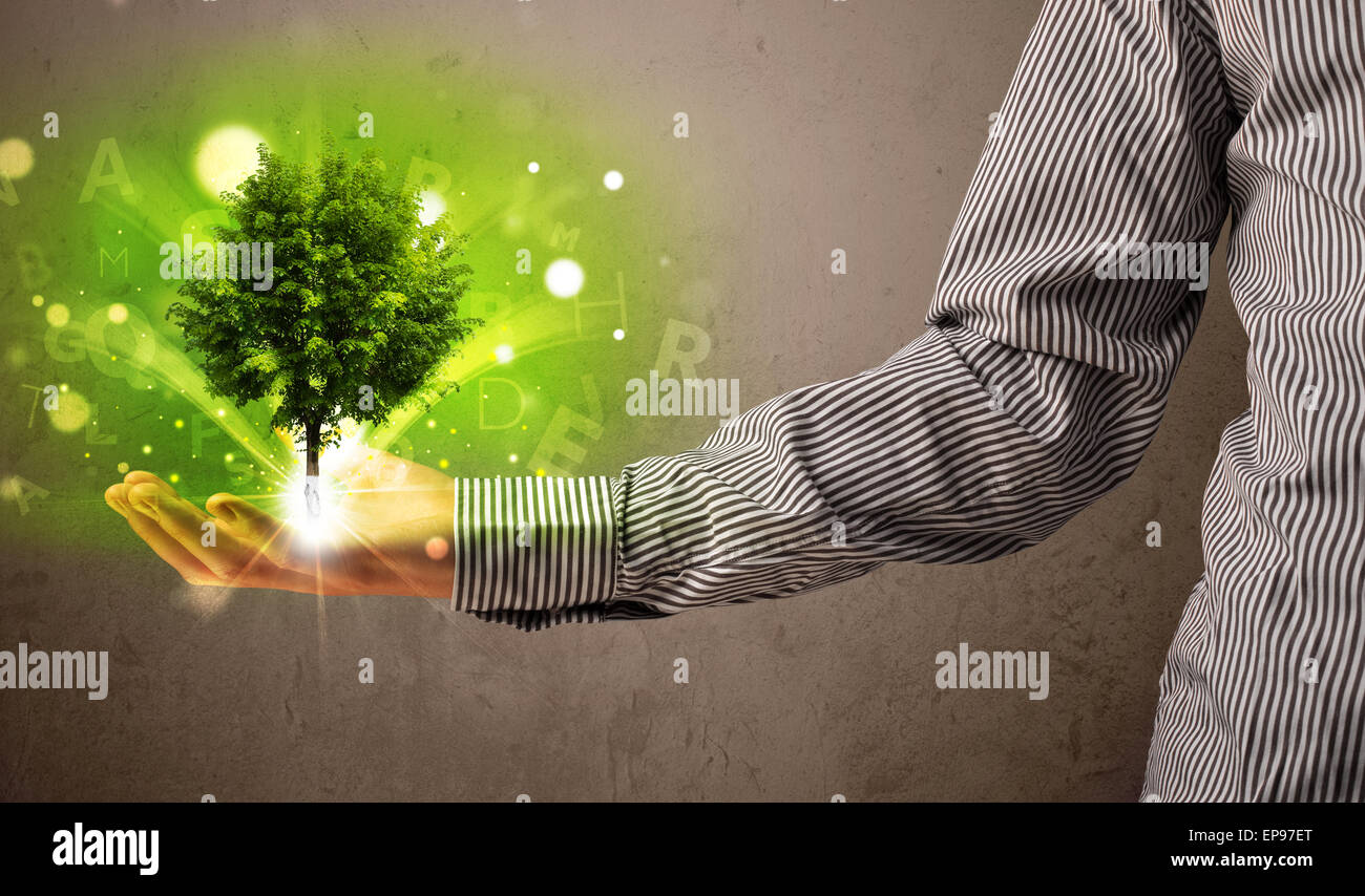 Glowing tree growing in the hand of a businessman Stock Photo - Alamy