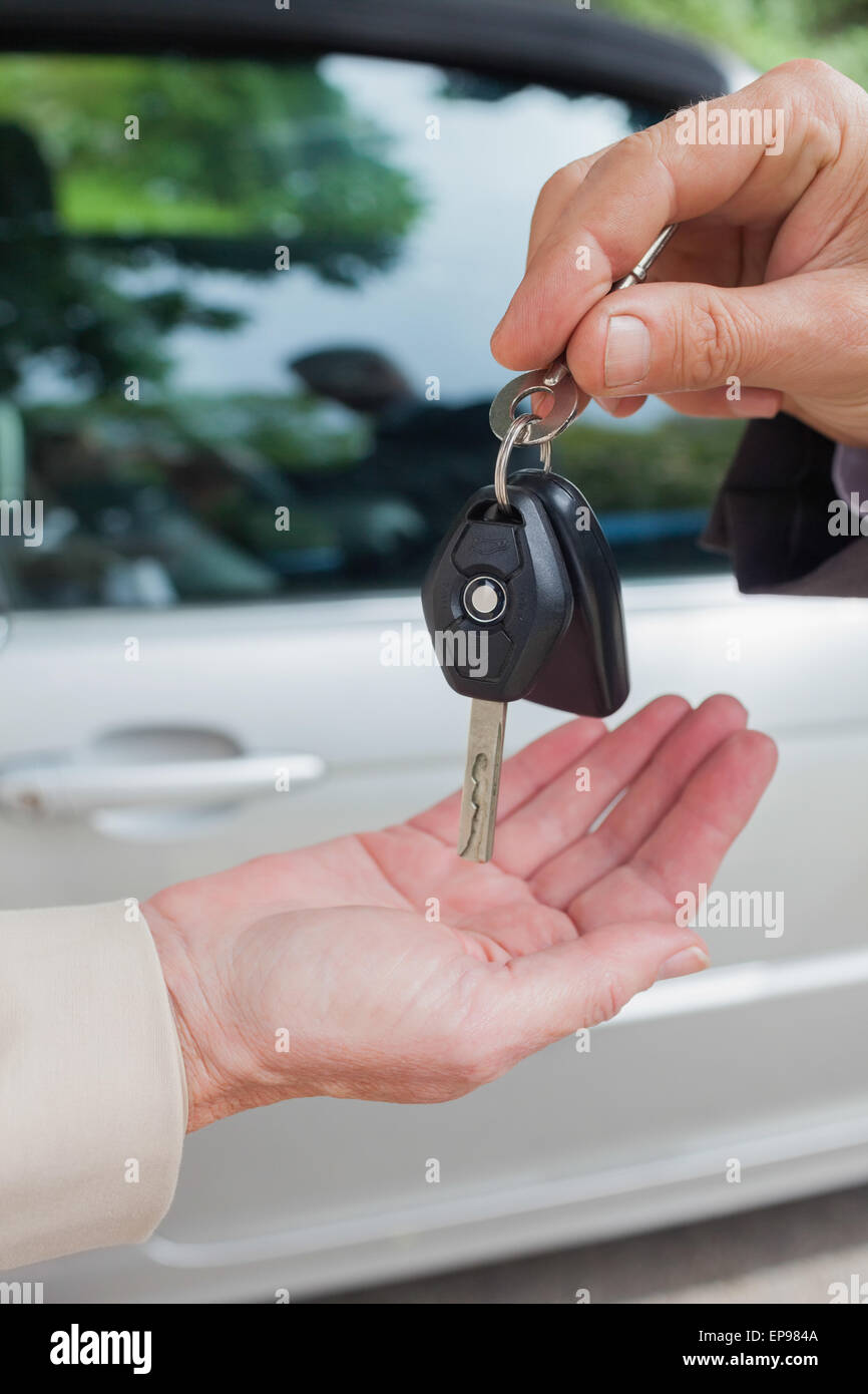 Close up on business man giving his keys to his female partner Stock ...