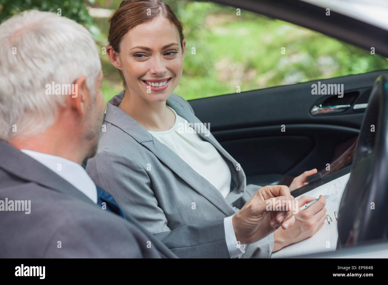 Smiling partners working together in classy car Stock Photo - Alamy