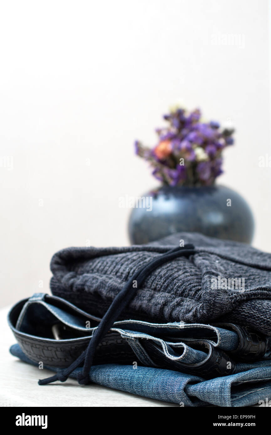 Stack of clothes on a Wooden table in front of the white wall Stock ...
