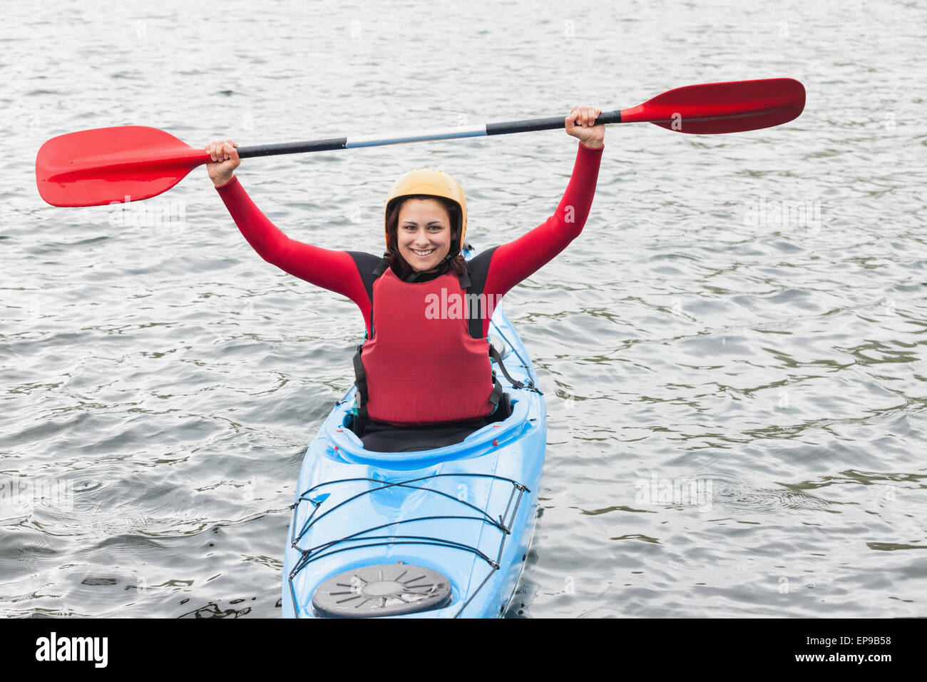 Smiling woman in a kayak cheering at the camera Stock Photo - Alamy