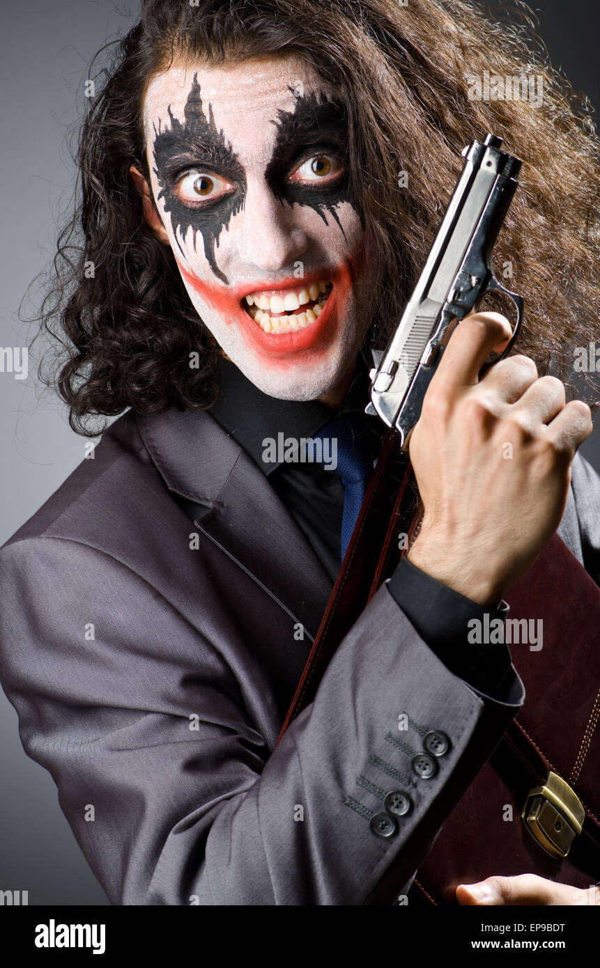 Joker with gun and briefcase Stock Photo - Alamy
