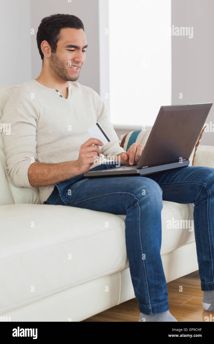 Smiling handsome man using his credit card to buy online Stock Photo ...