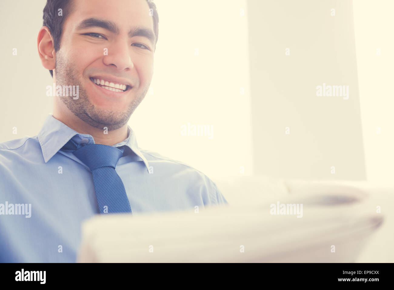 Laughing man looking at camera and reading a newspaper Stock Photo - Alamy