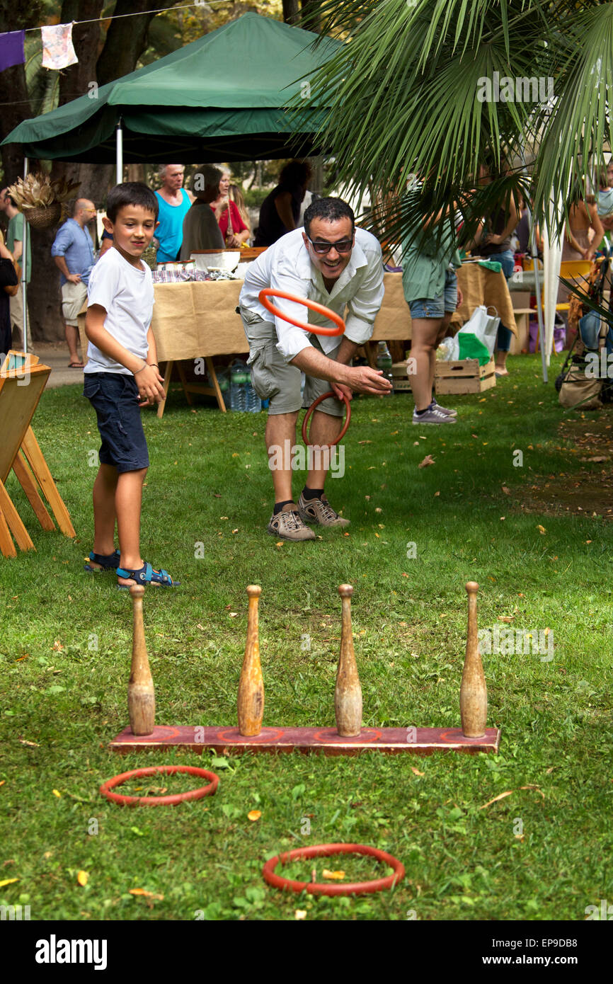 Competitive Dad throwing a hoop over a skittle Stock Photo - Alamy