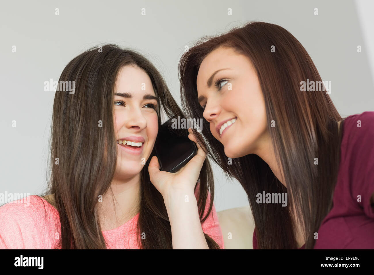 Two cheerful girls calling someone with a mobile phone Stock Photo - Alamy