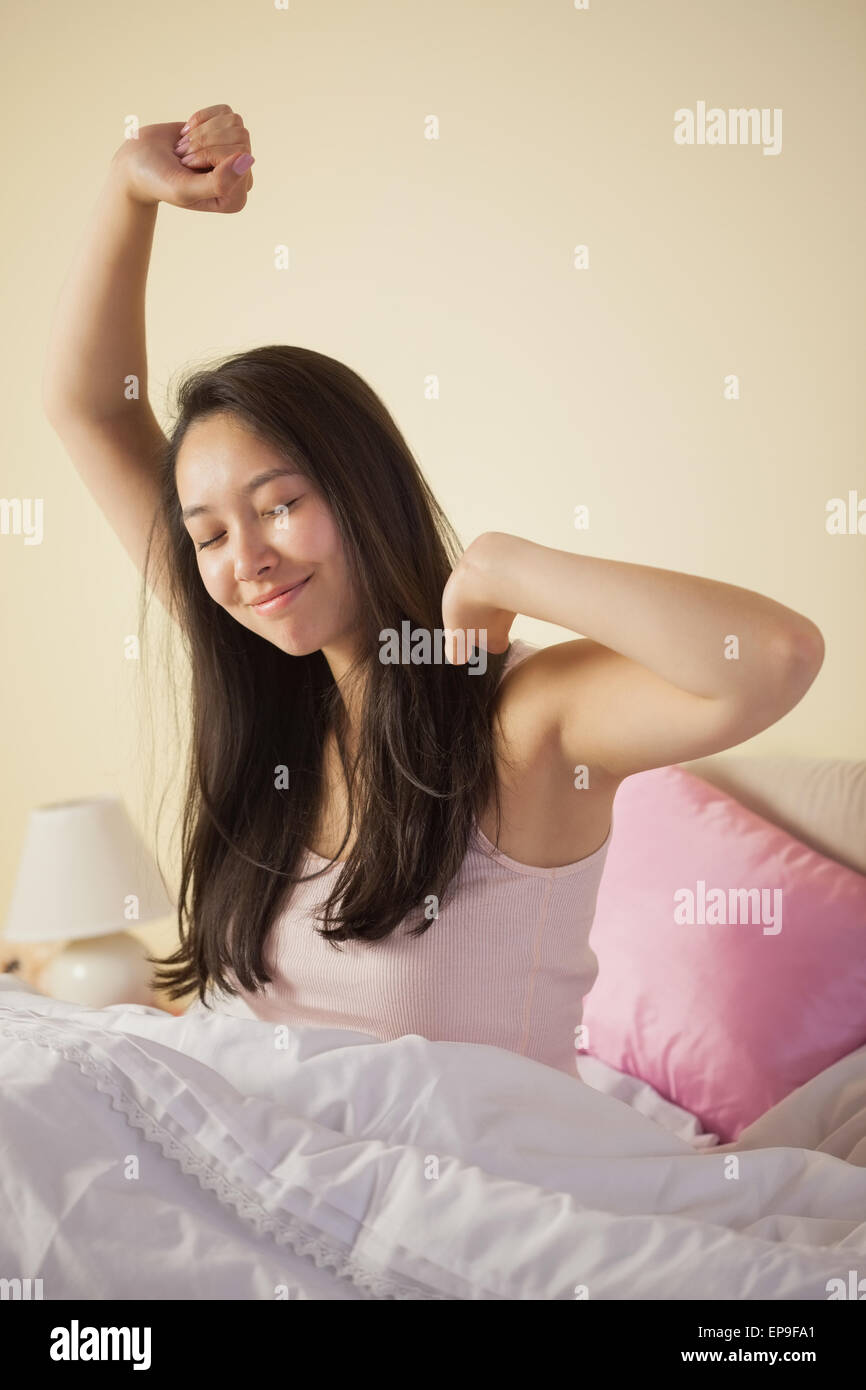Young asian woman stretching in bed in the morning Stock Photo - Alamy
