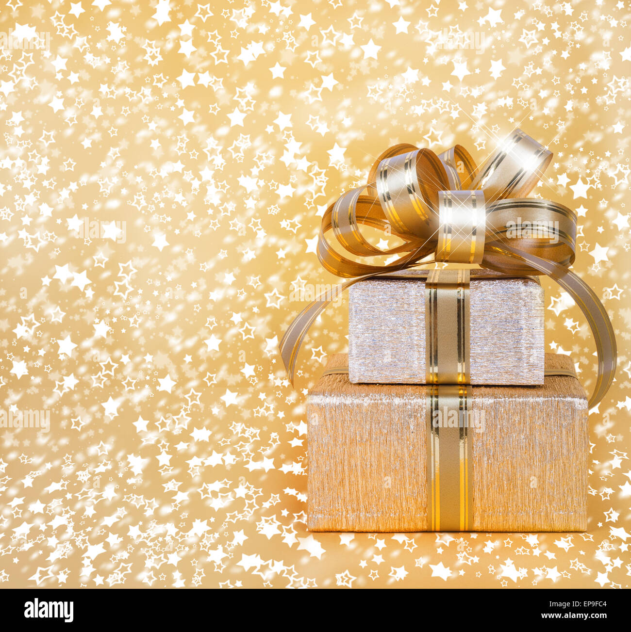 Gift box in gold wrapping paper on a beautiful abstract background ...