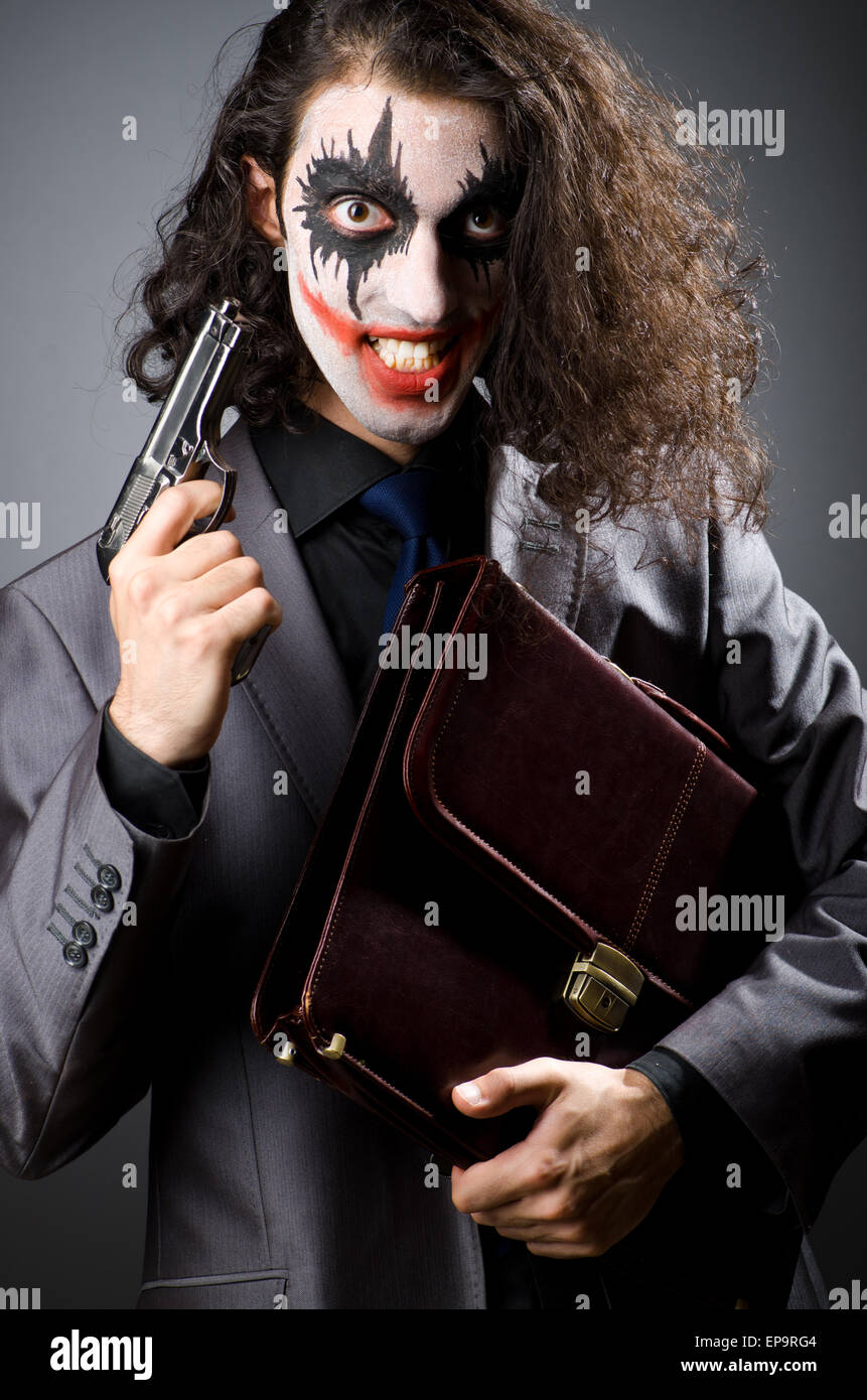 Joker with gun and briefcase Stock Photo - Alamy