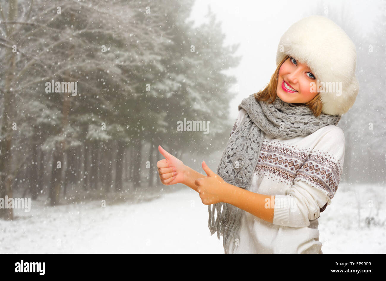 Young smiling girl shows ok gesture at snowy forest Stock Photo - Alamy
